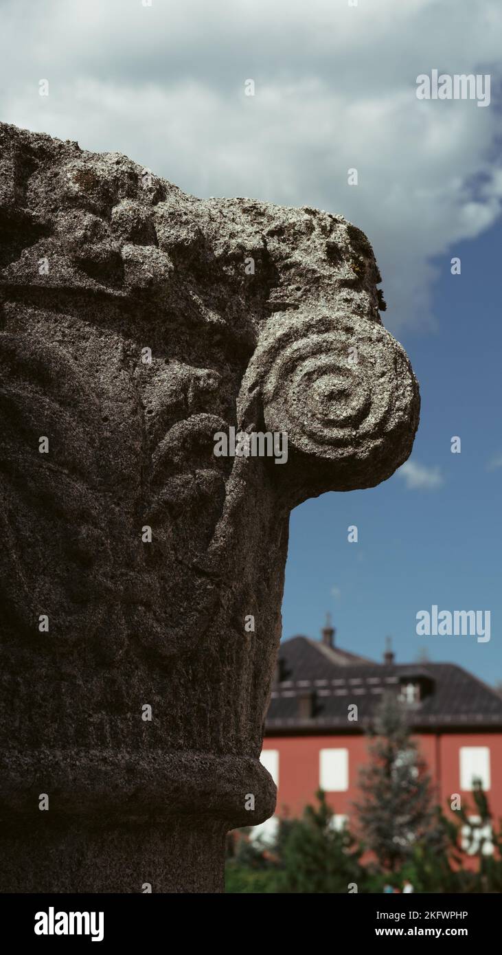 A vertical closeup of an ancient stone column with ornaments under ...
