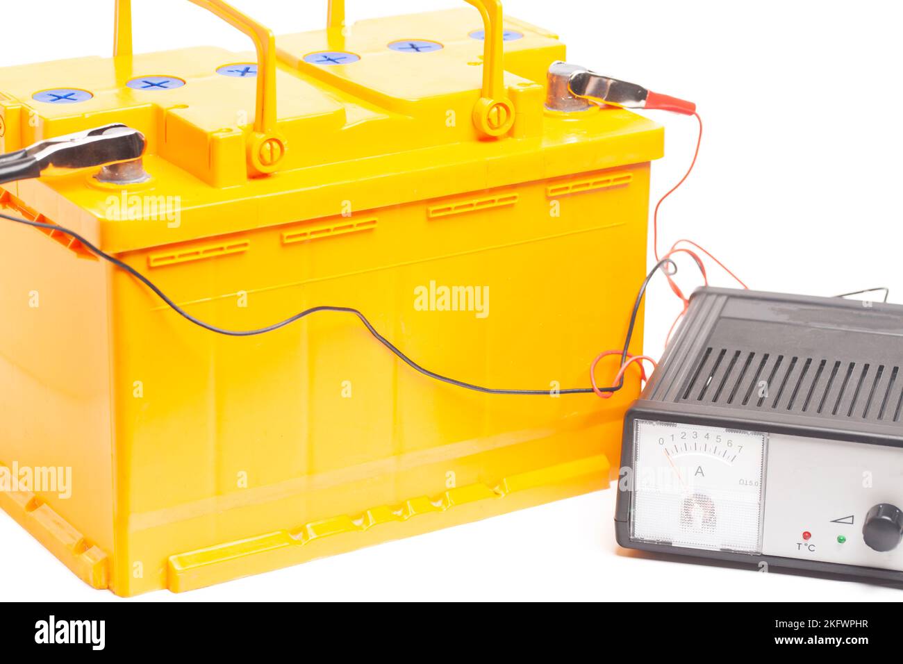 yellow car battery with car battery charger isolated on white ...