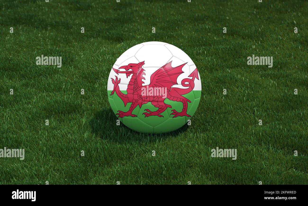 Soccer ball with wales flag colors at a stadium on green grasses ...