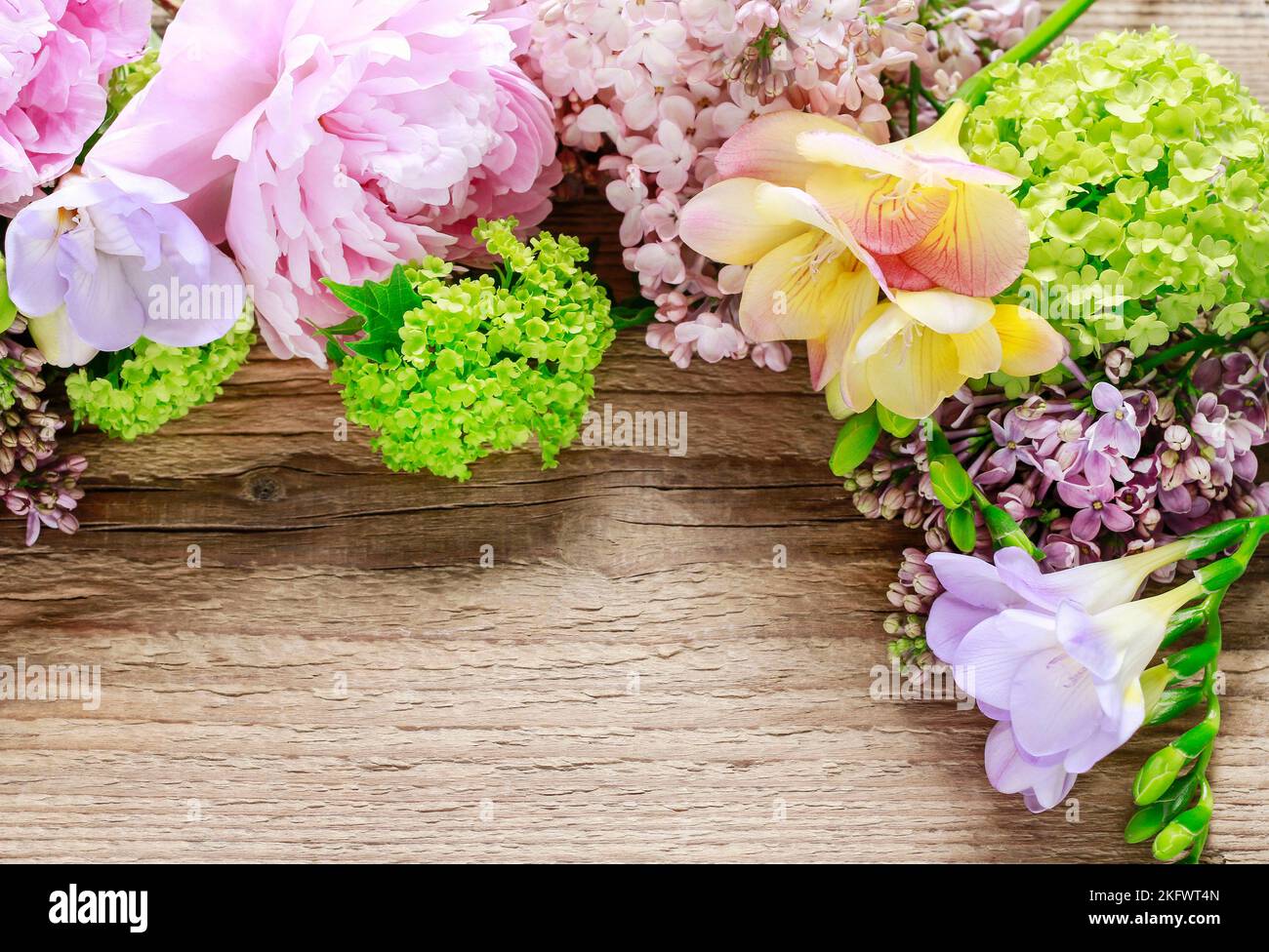 Lilacs, peonies and green guelder rose (viburnum opulus) on wooden ...