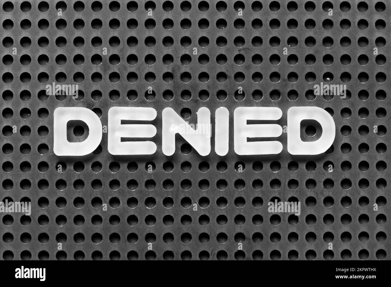 White alphabet letter in word denied on black pegboard background Stock ...