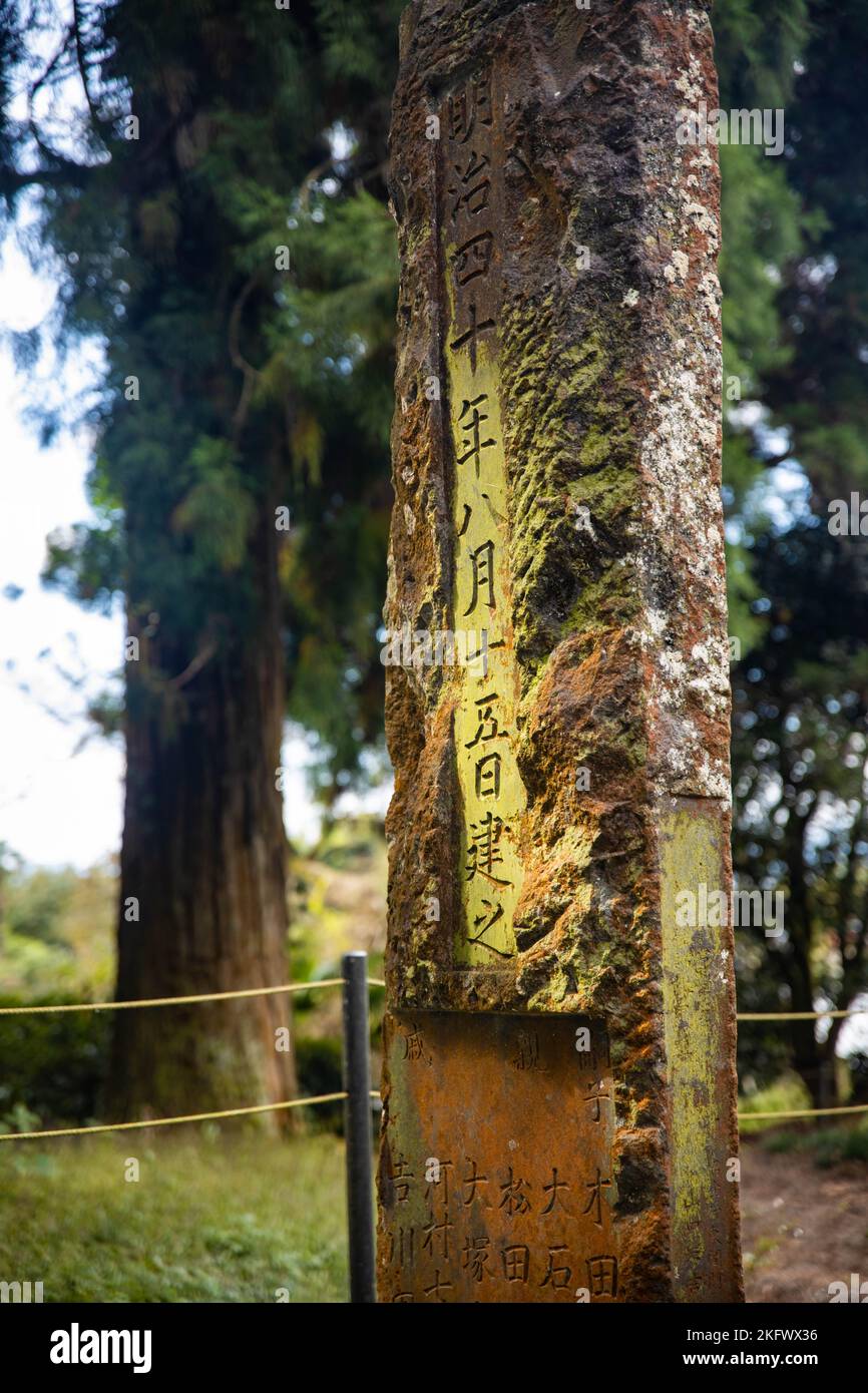 Stone monument with carved japanese words in forest shrine in Japan ...