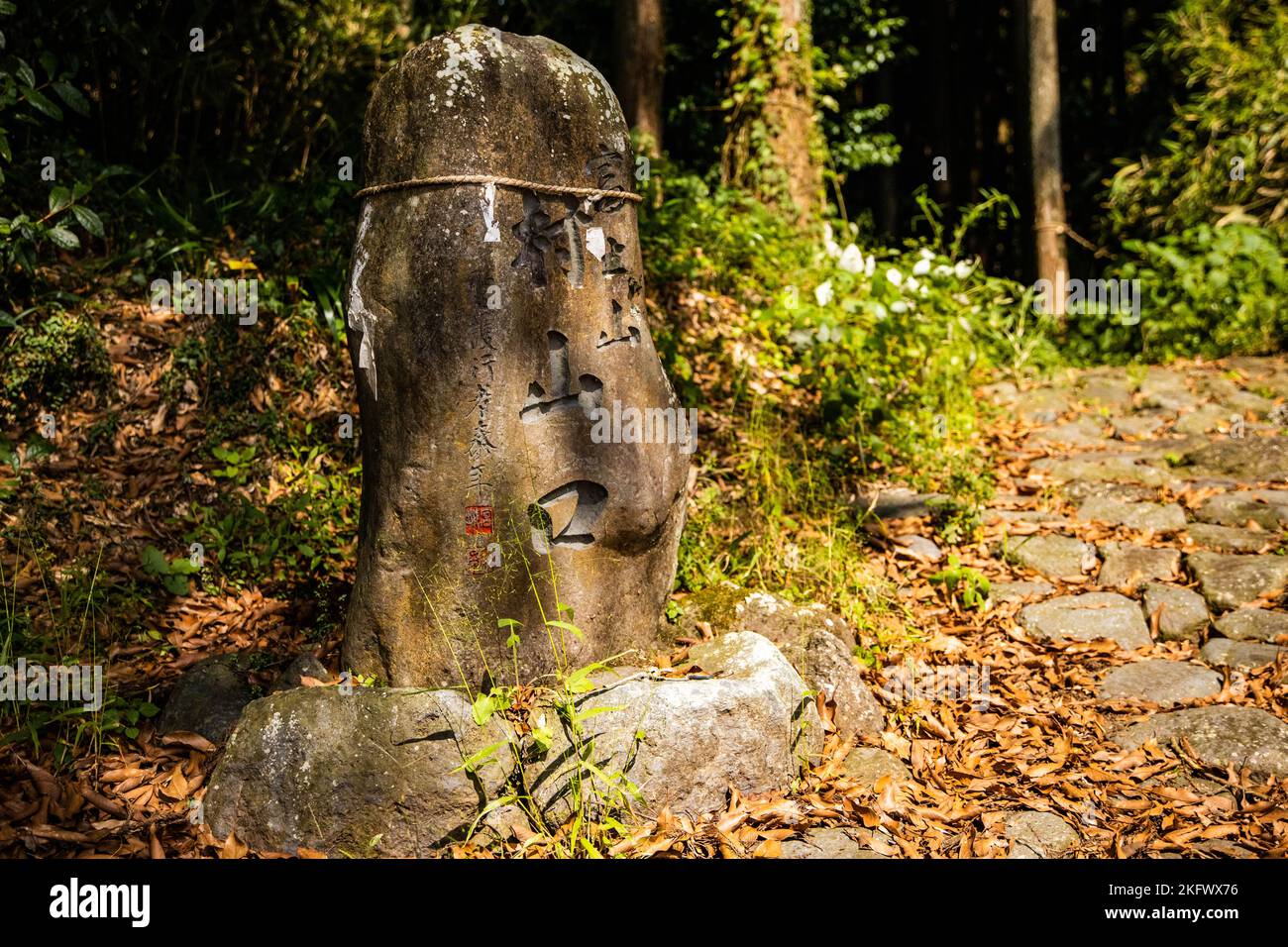 Stone monument with carved japanese words in forest shrine in Japan ...