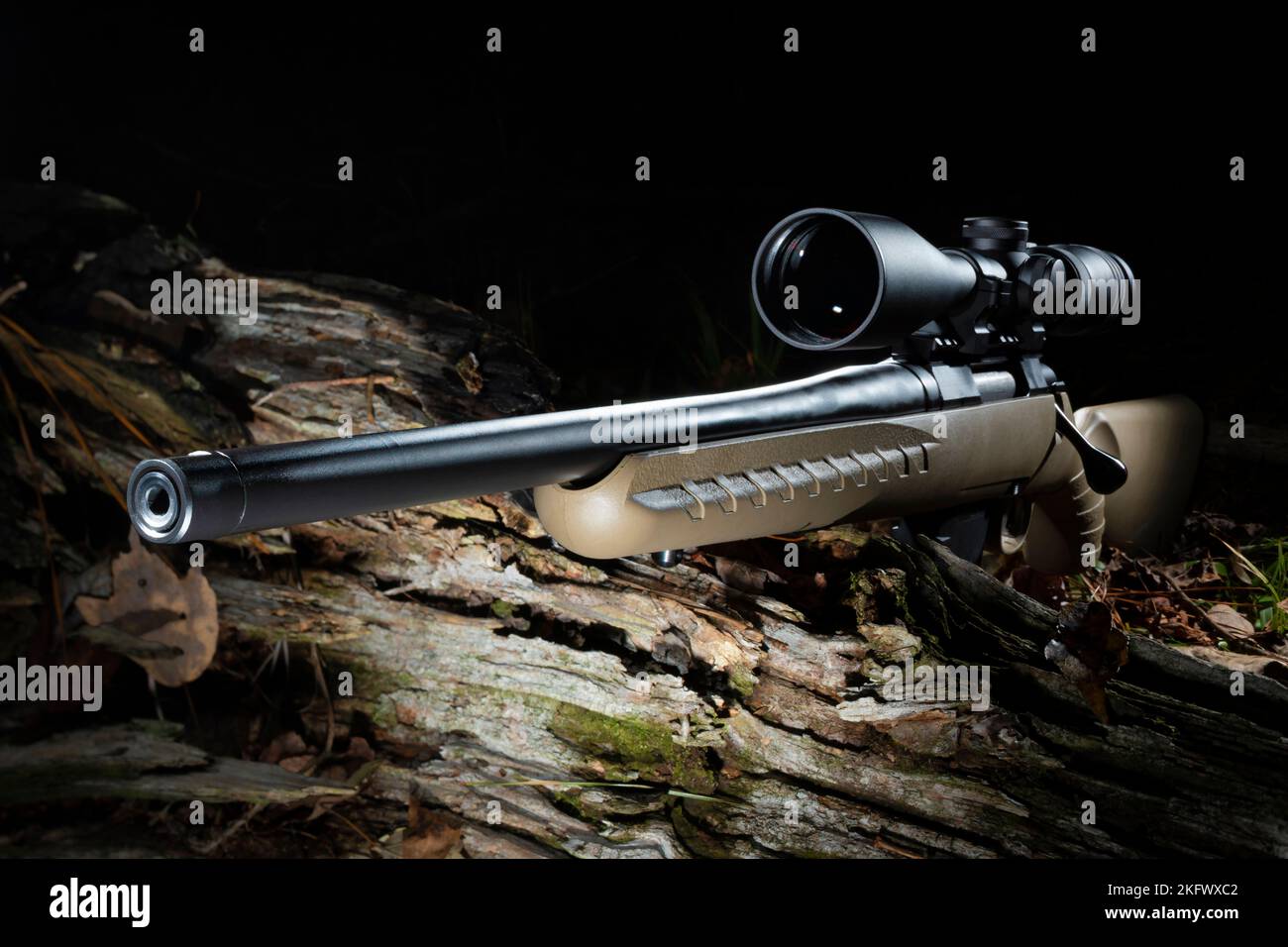 High powered optic on a bolt action hunting rifle in a dark forest ...
