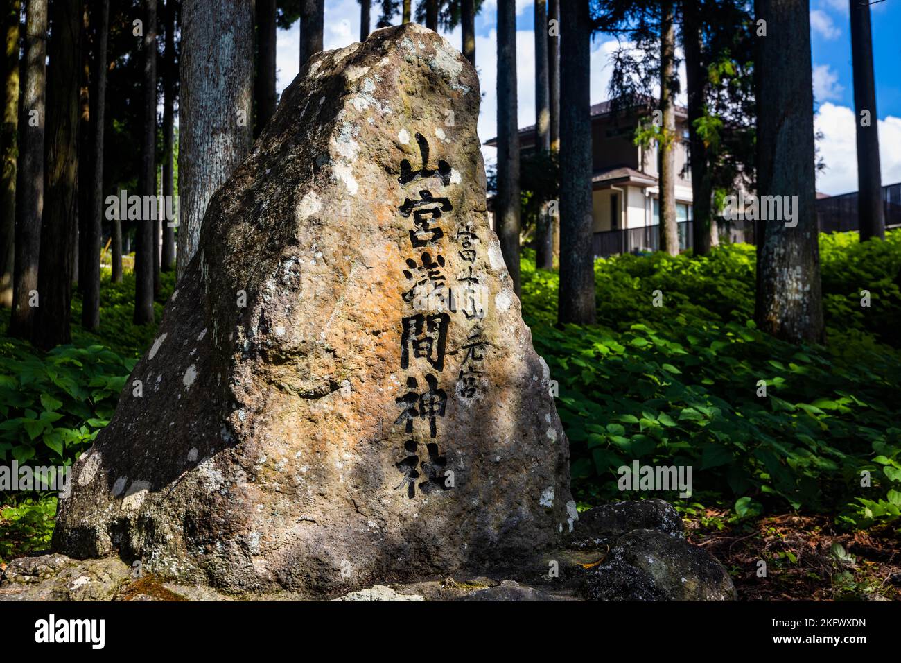 Stone monument with carved japanese words in forest shrine in Japan ...