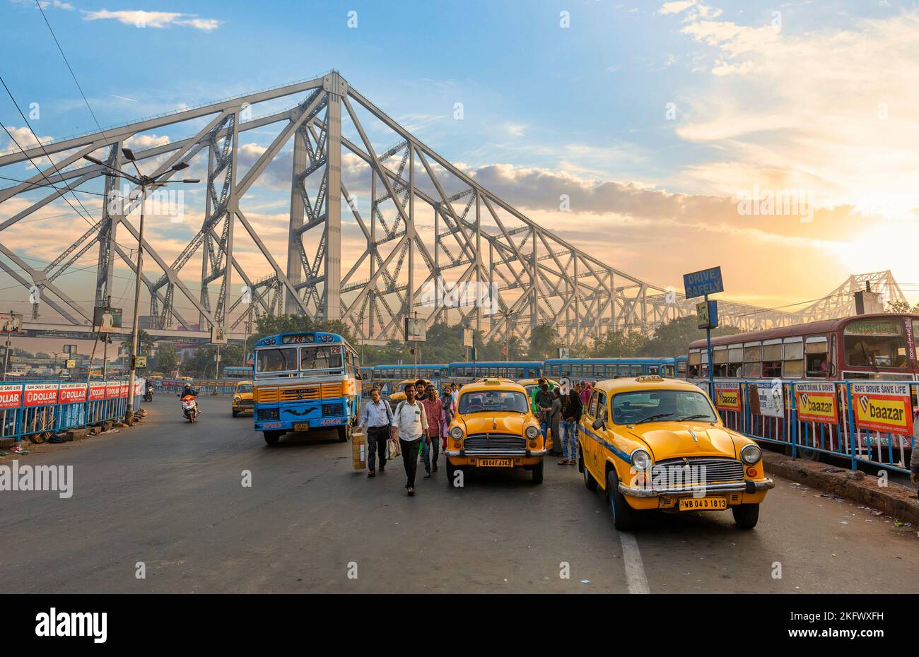 Public transport vehicles on city road near historic Howrah bridge ...