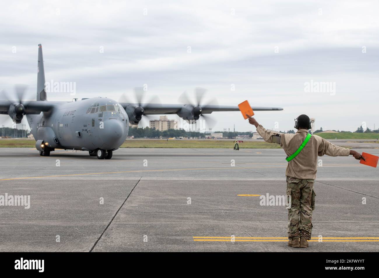 A 374th Maintenance Group Airman marshals a C-130J Super Hercules ...