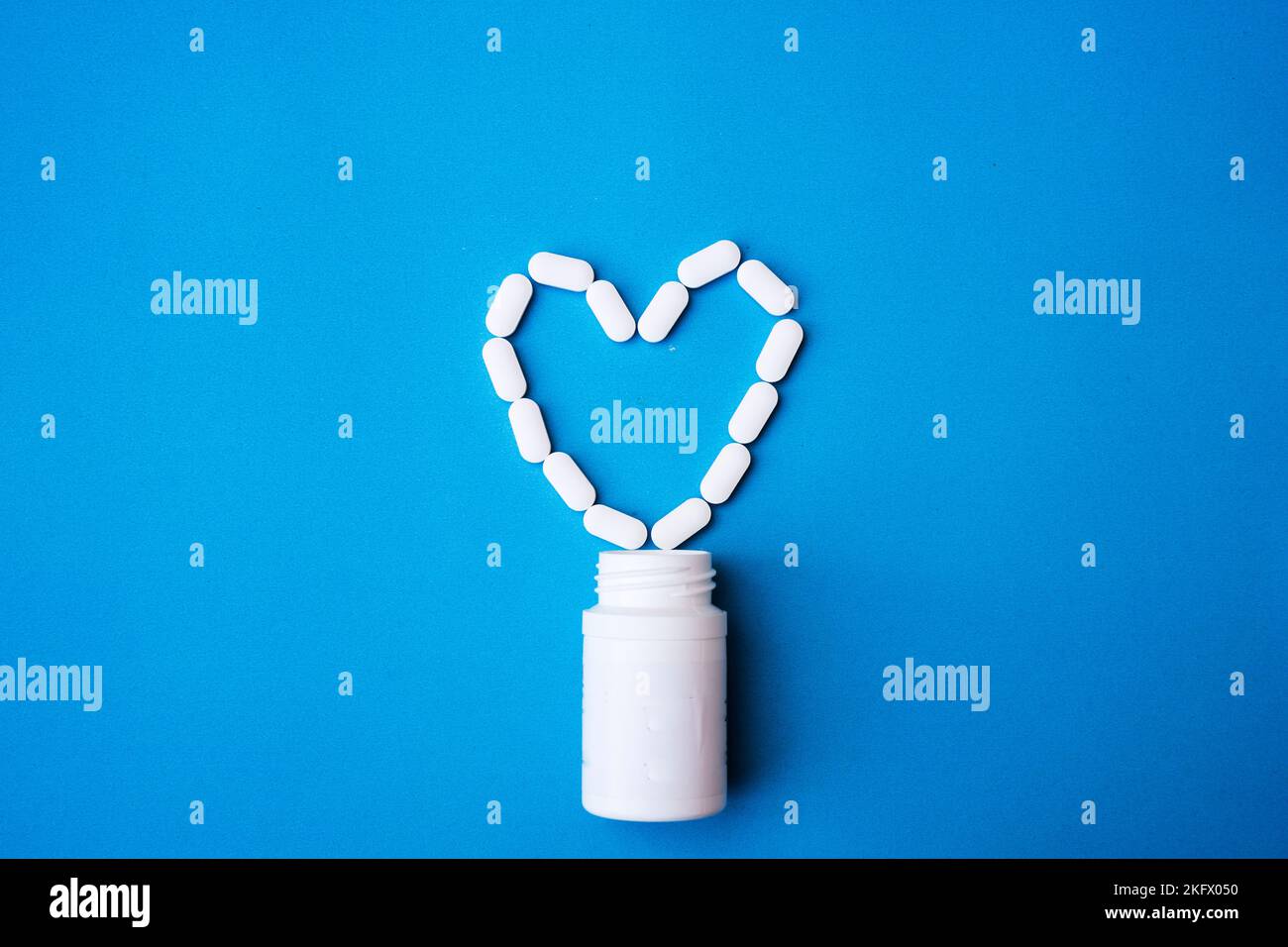 medicine white tablets and medicine bottle isolated on blue background ...