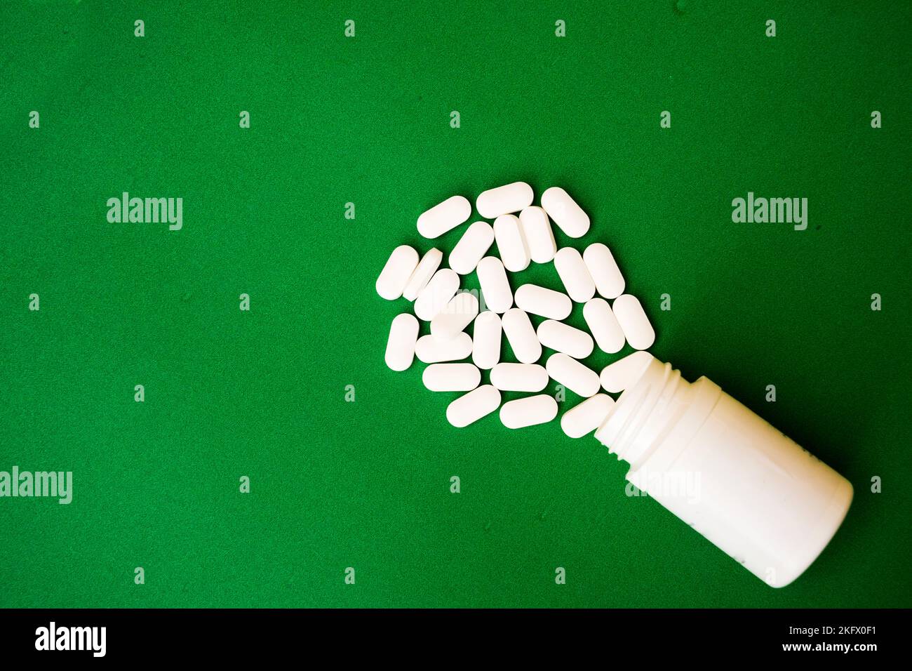 Pills , tablets, pill bottle isolated on green. Top view with copy ...