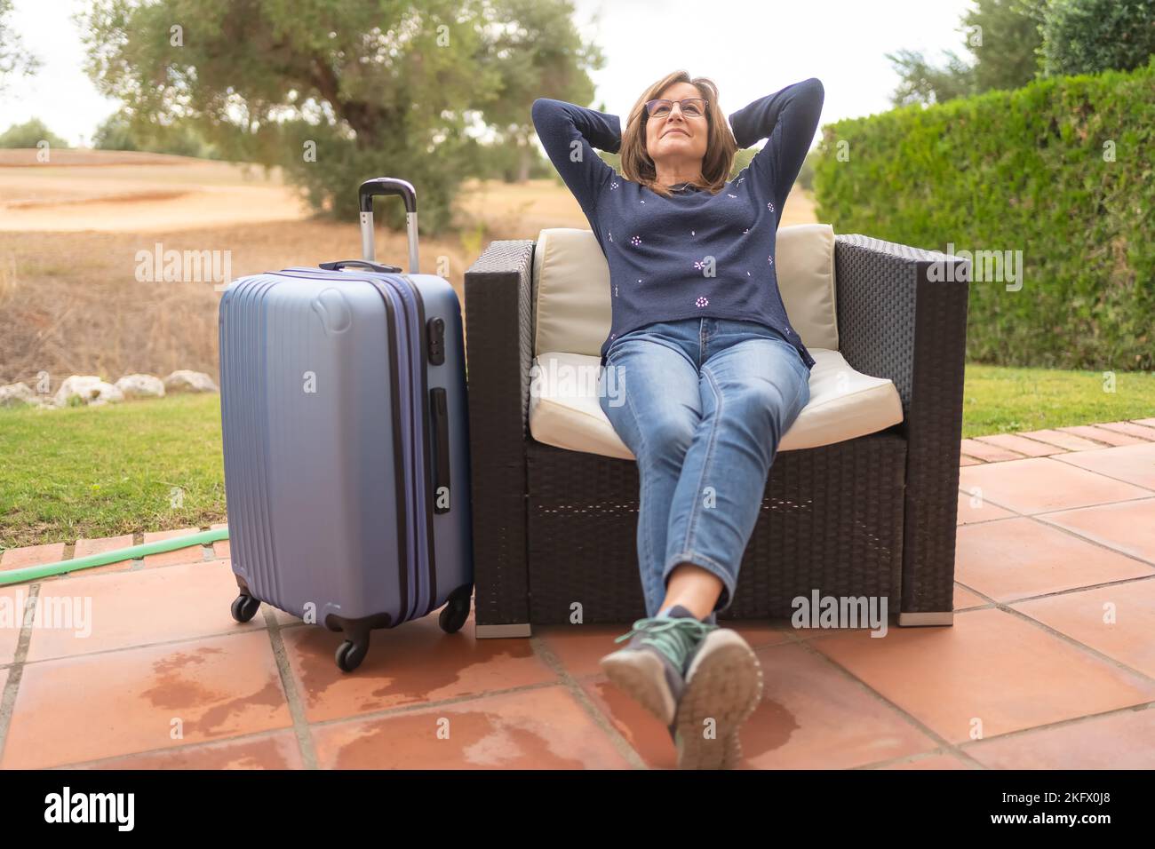 Woman in relaxed and happy posture, sitting in her apartment on arrival ...