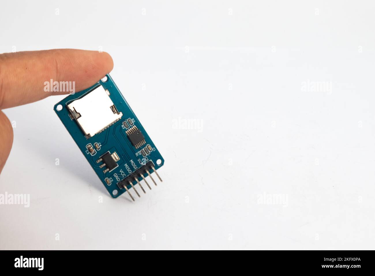 A microSD card reader module held by a finger. This module is used for ...