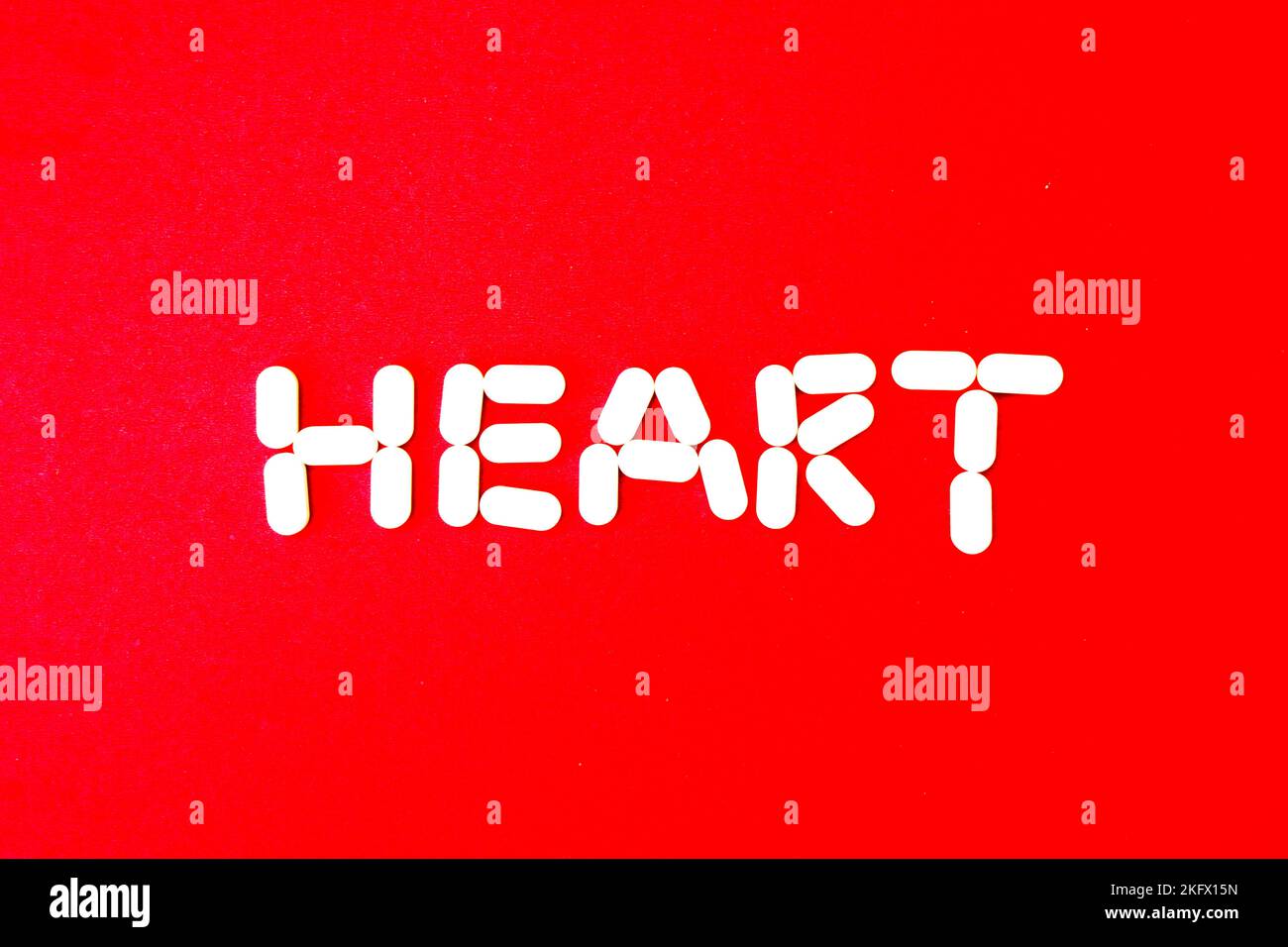 the word heart is written with pills on a red background Stock Photo ...