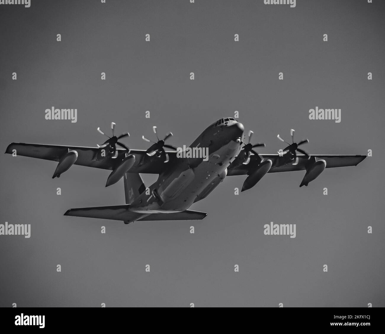 A low-angle grayscale of Lockheed C-130 Hercules aircraft model flying ...