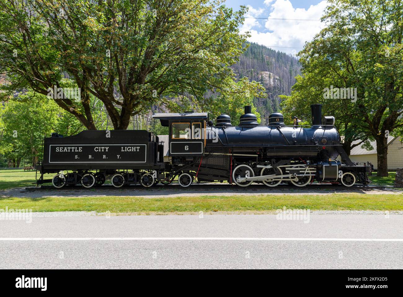 An old chapel and an old train in front of a mountain and trees Stock ...