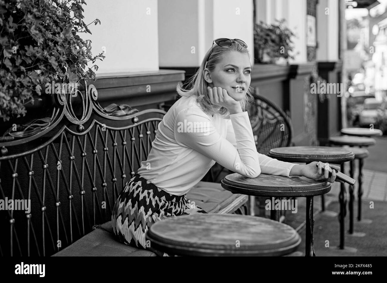 Whom should I call. Woman curious face sit with smartphone cafe terrace ...