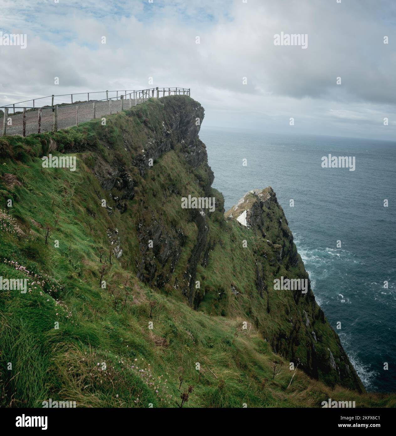 Kerry cliffs with green grass and dramatic clouds in cloudy autumn day ...