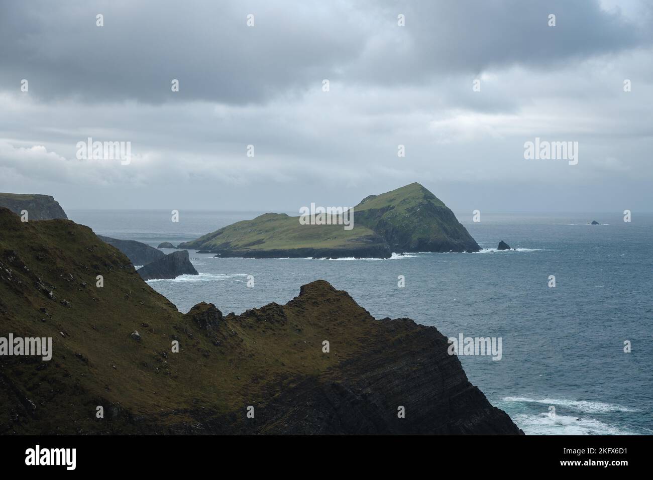 Kerry cliffs with green grass and dramatic clouds in cloudy autumn day ...