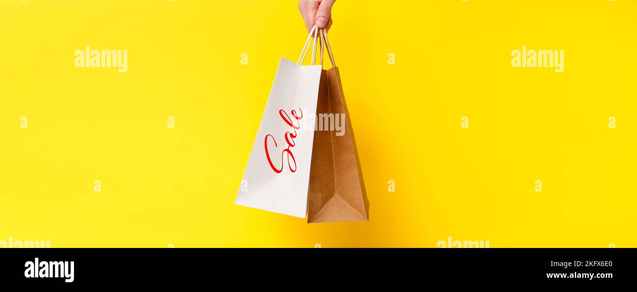 Sale, special offer banner. Female hand holding two shopping bags ...