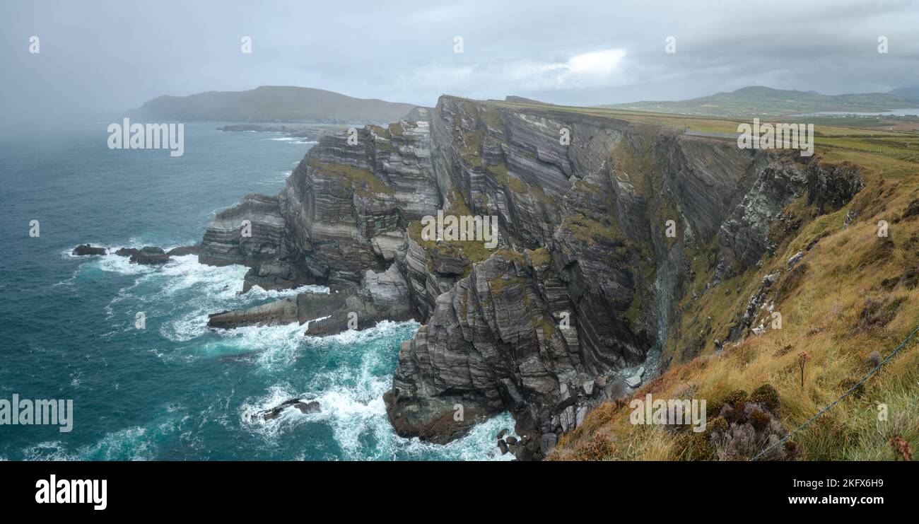 Kerry cliffs with green grass and dramatic clouds in cloudy autumn day ...