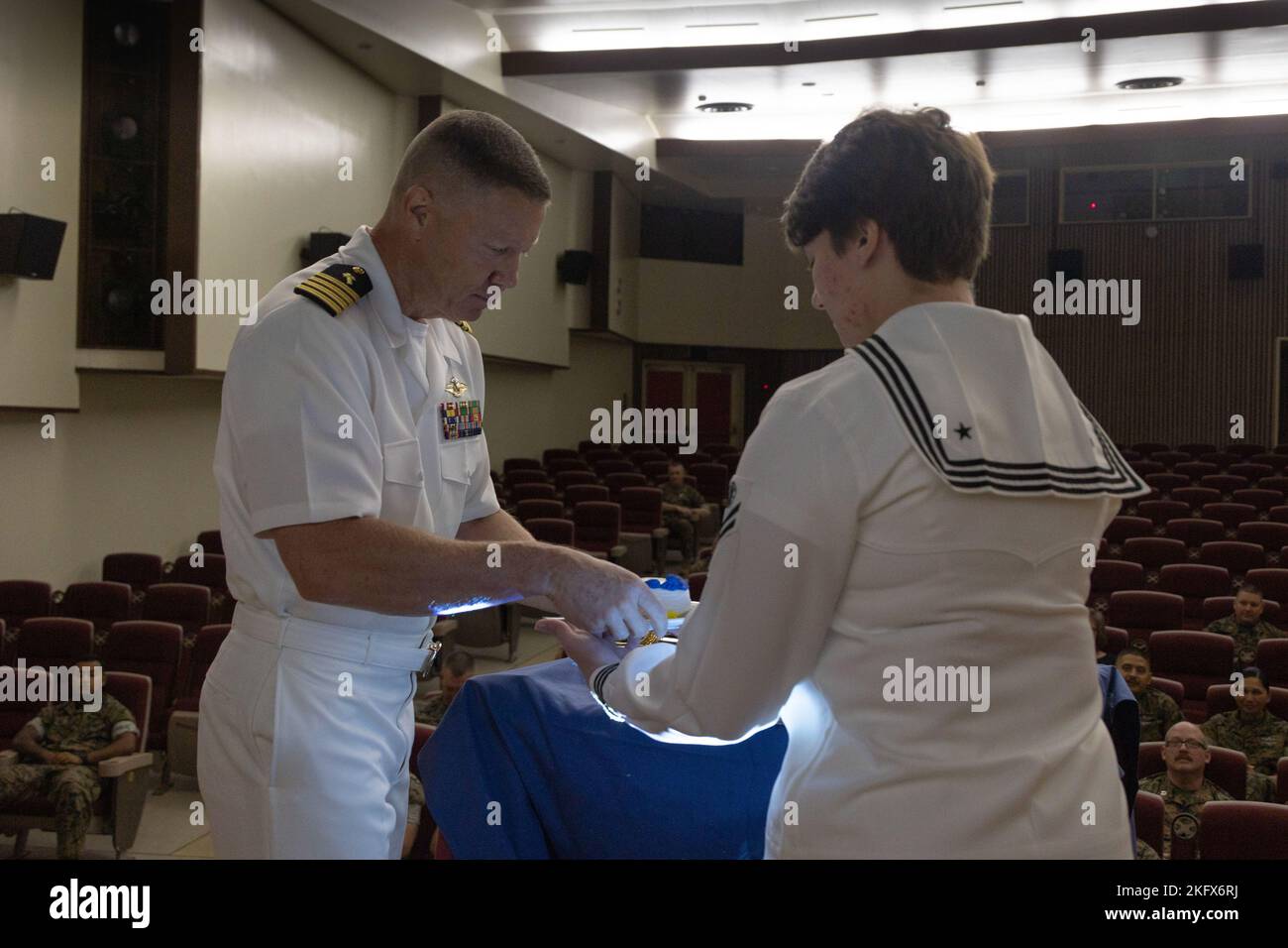 U.S. Navy Capt. Robert Hall, a chaplain, hands a piece of cake to religious program specialist ...