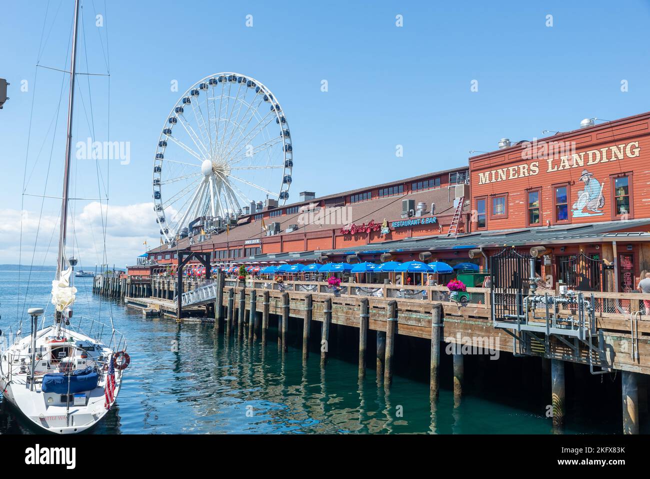 A scenic view of the Seattle pier at water with Ferris wheel in the ...