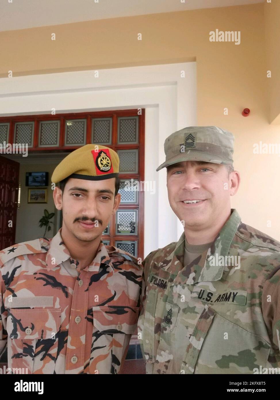 A member of 158th MEB Military Engagement Team 2 poses with a member of ...