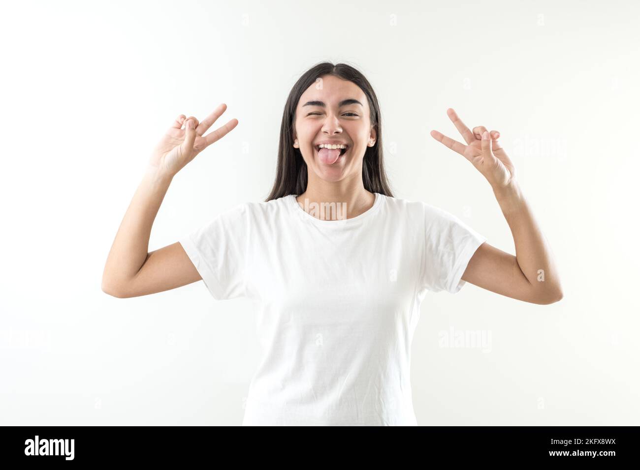 Young girl raises her fingers in victory and winks Stock Photo - Alamy