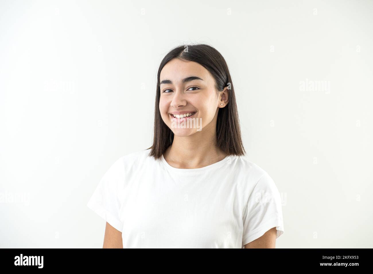 Happy and smiling young girl looking at camera in studio Stock Photo ...