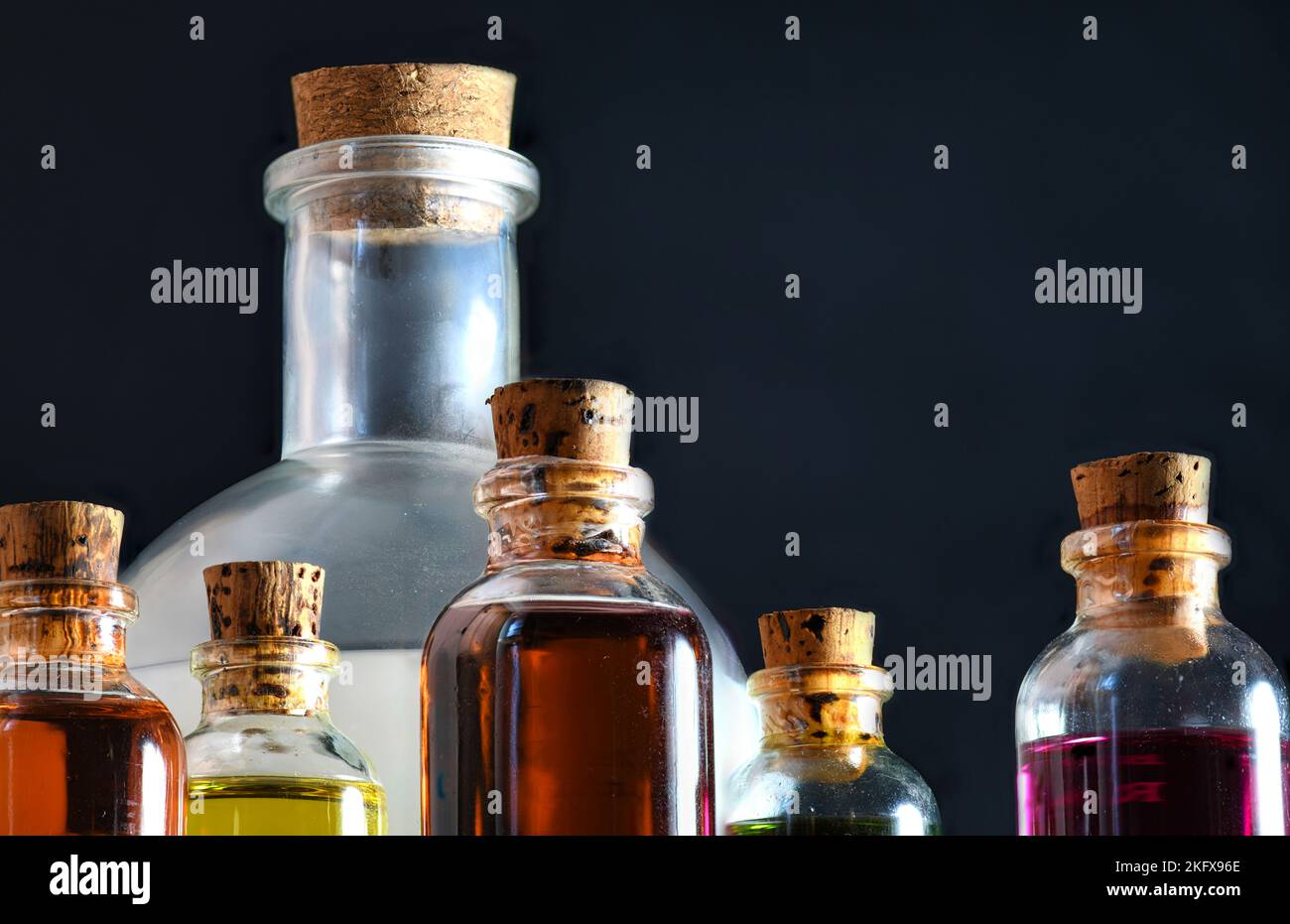 Colored Oil bottles on a black background Stock Photo - Alamy
