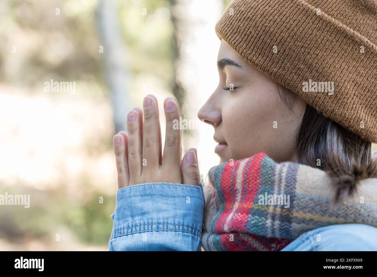 Young girl in cap rubs her hands together to warm Stock Photo - Alamy