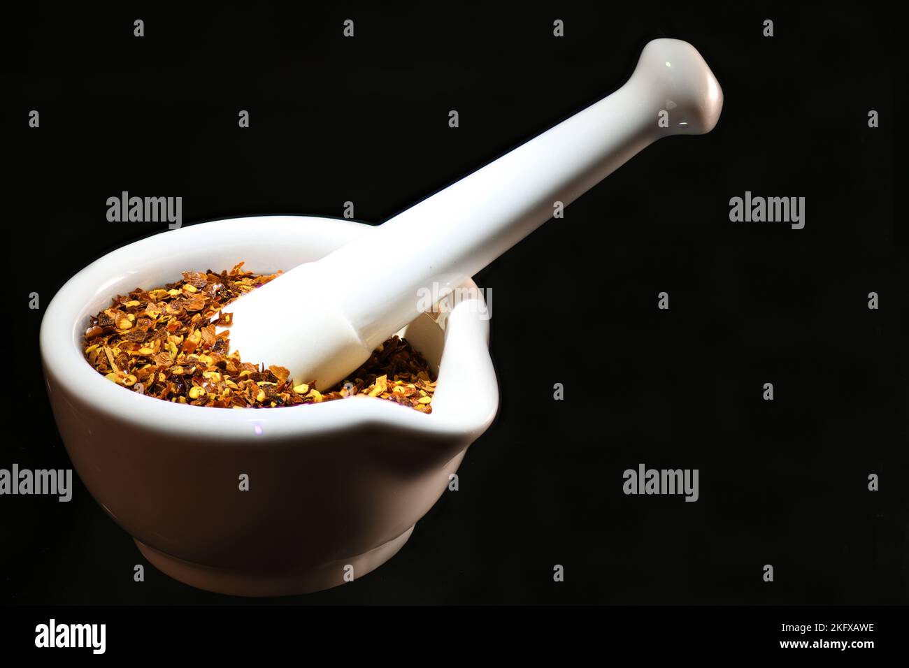 Red Chili in Mortar and Pestle on black background Stock Photo - Alamy