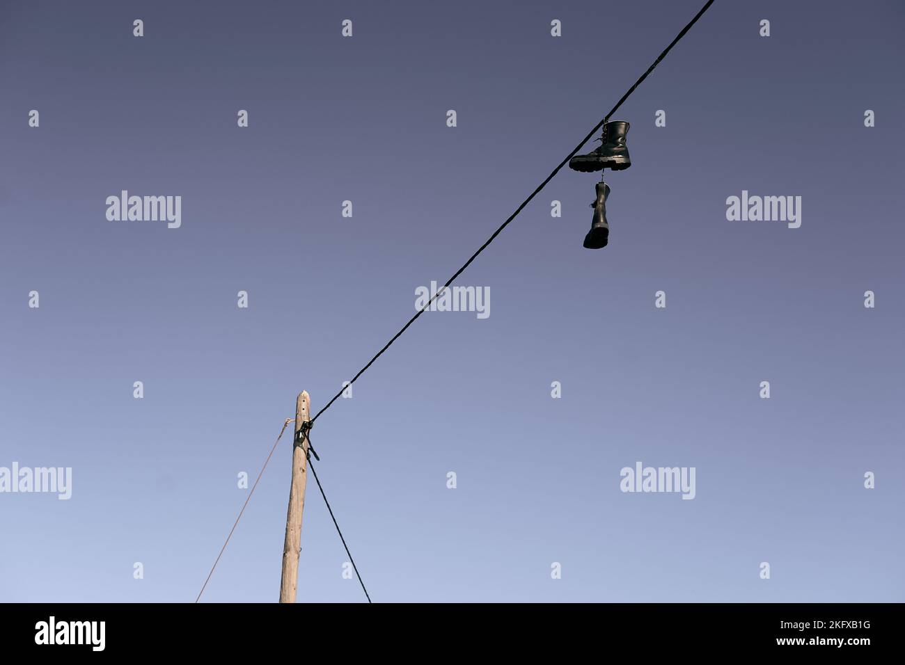 a pair of military boots with the laces attached to an electrical wire ...