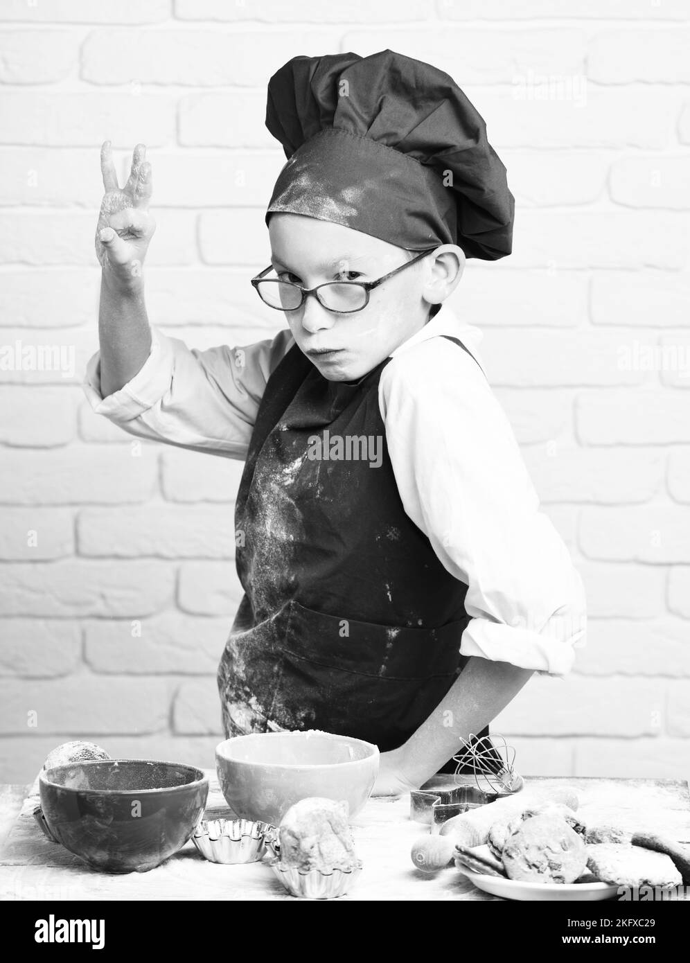 young boy cute cook chef in red uniform and hat on stained face with ...