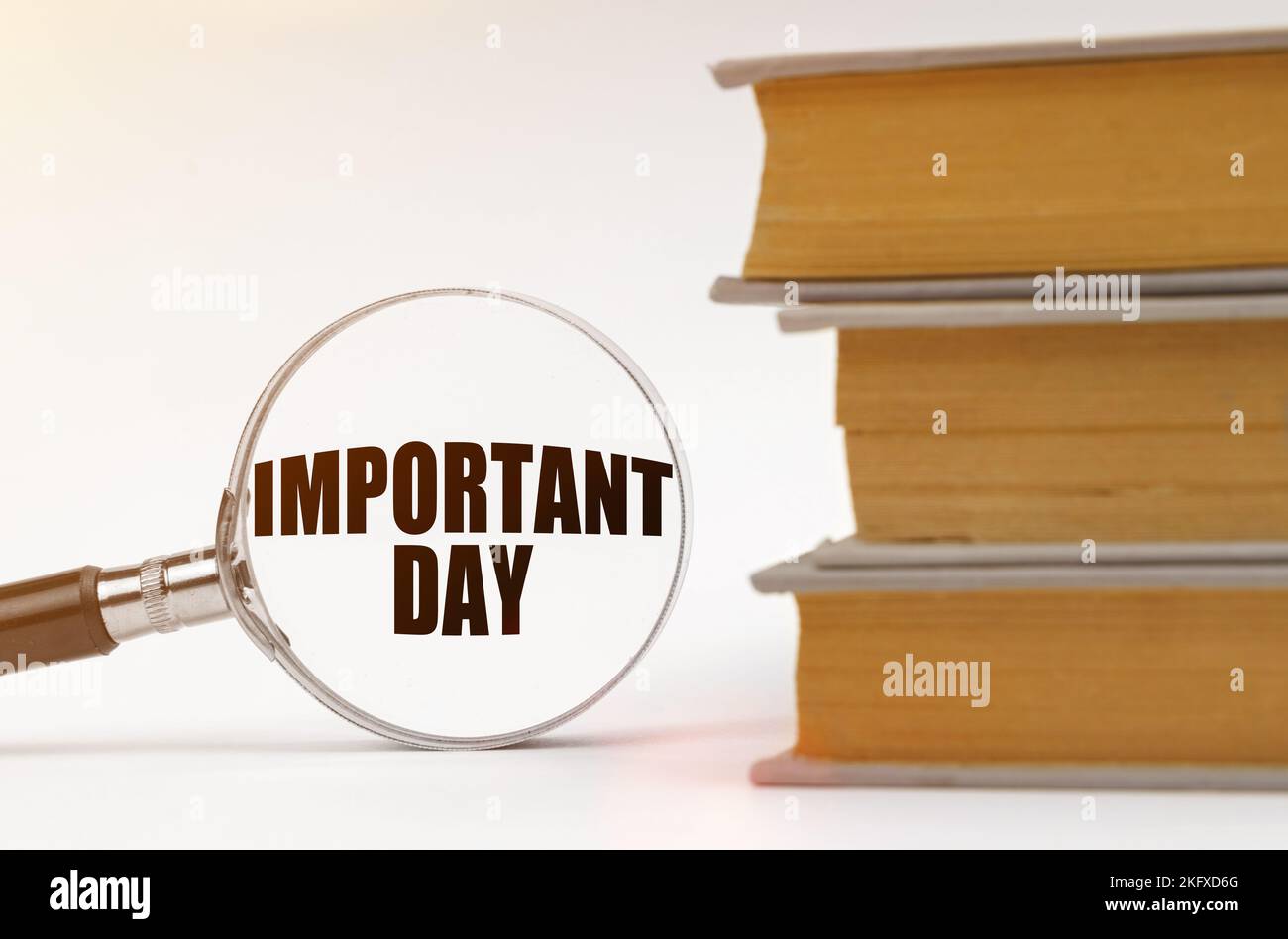 Business concept. On a white background, books and a magnifying glass ...