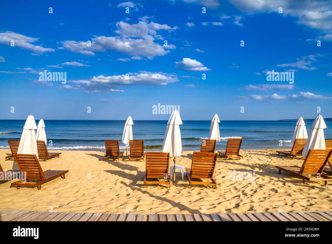 Coastal landscape - Beach umbrellas and loungers on the sandy seashore ...