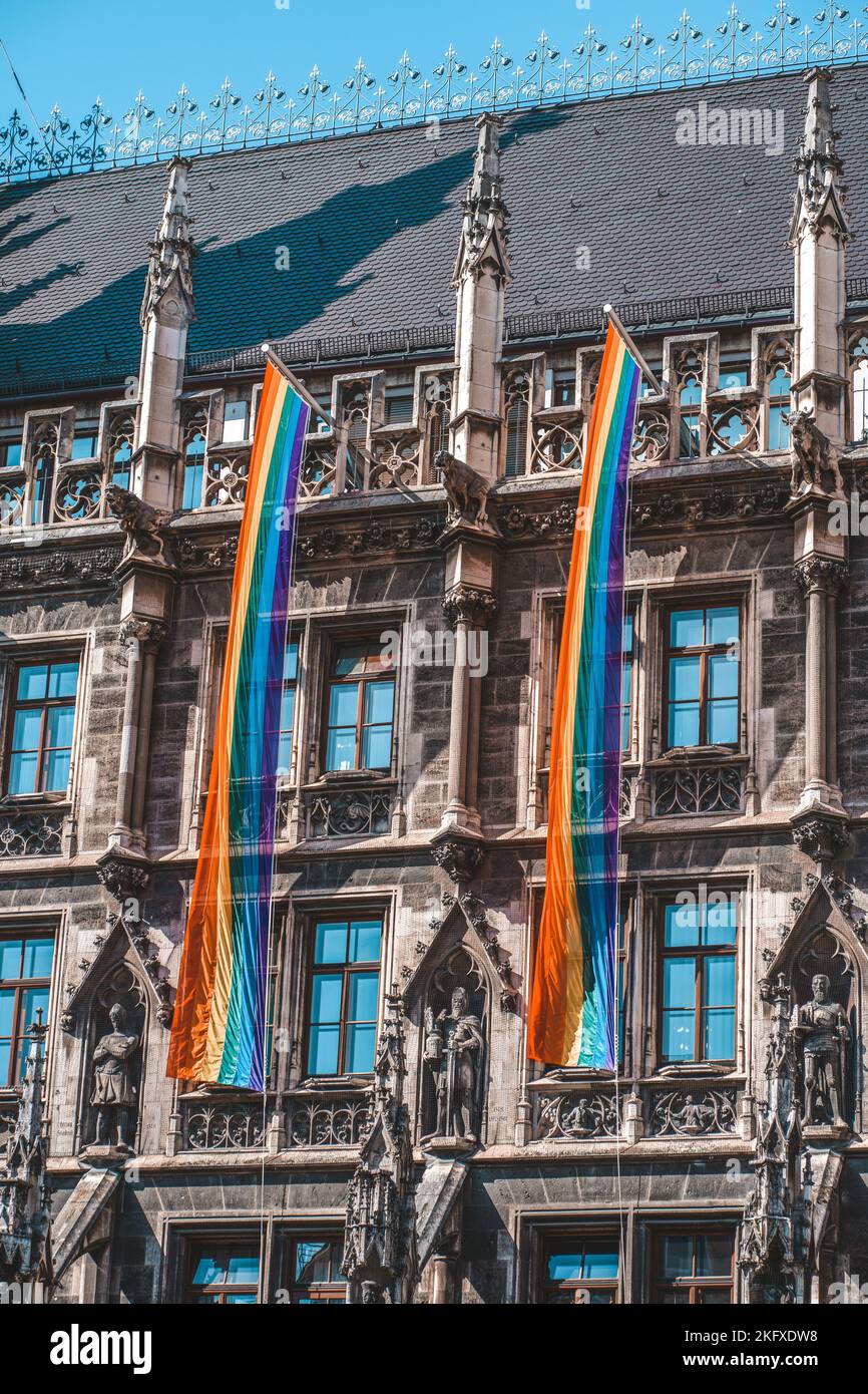 A vertical of two long pride flags hanging from an old style ...