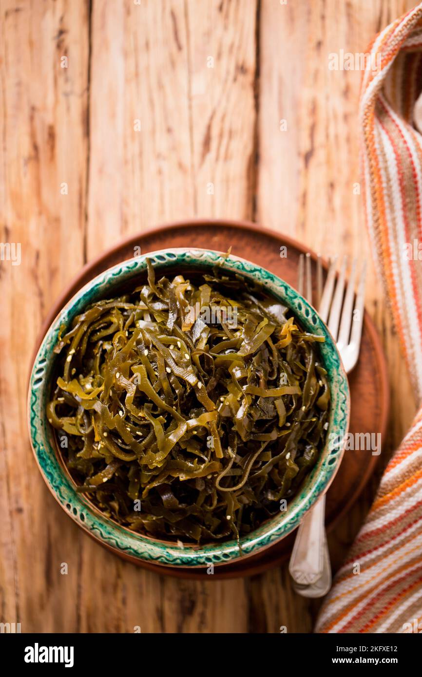 Sea cabbage salad in a bowl on a wooden table Stock Photo - Alamy