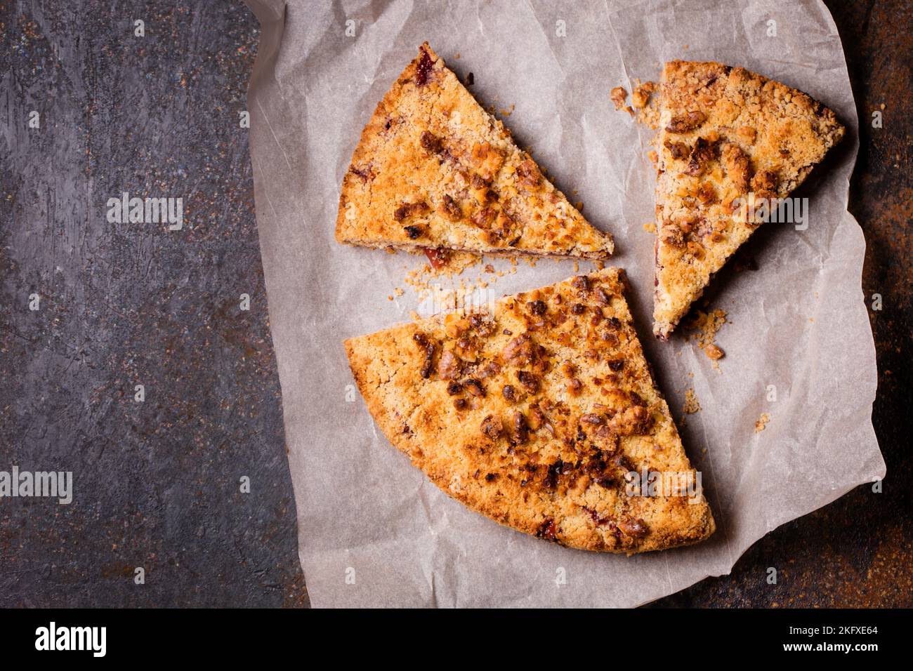 Grated cake with jam and nut filling on parchment Stock Photo - Alamy