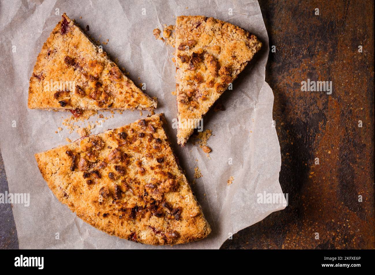 Grated cake with jam and nut filling on parchment Stock Photo - Alamy