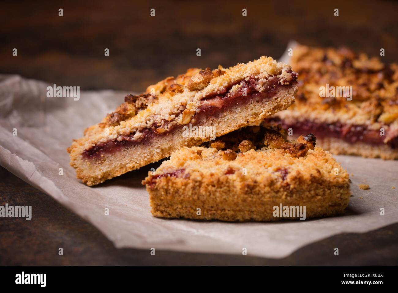 Grated cake with jam and nut filling on parchment Stock Photo - Alamy