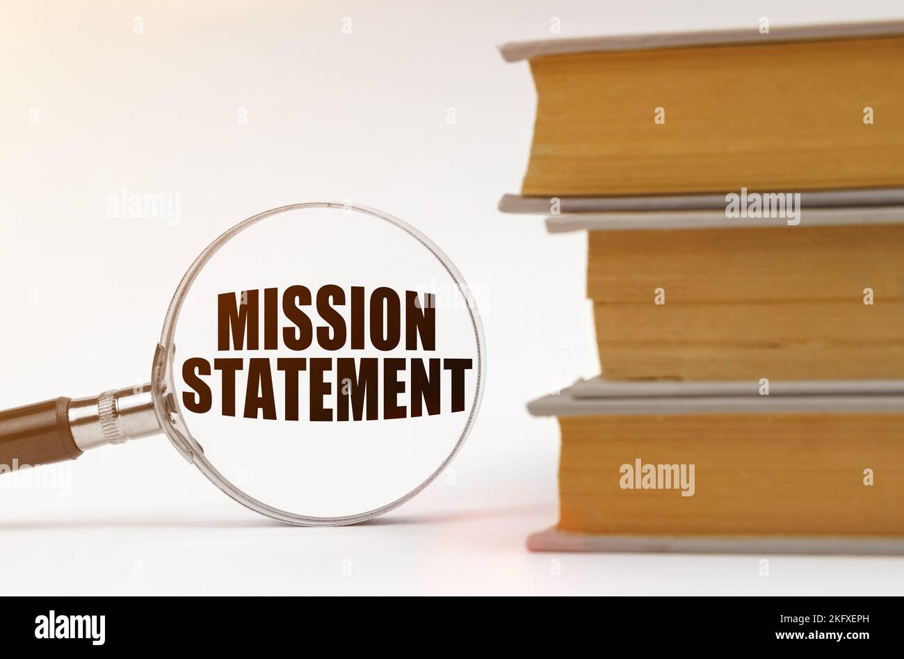 Business concept. On a white background, books and a magnifying glass ...