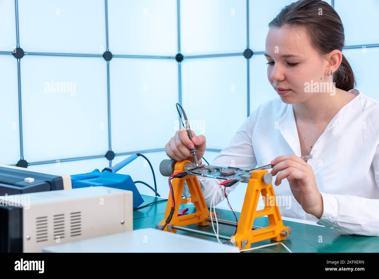 girl student studying the work of an electronic device in the ...