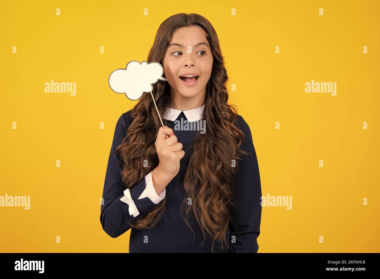 Teen girl holding thinking bubble, comment cloud over yellow background ...