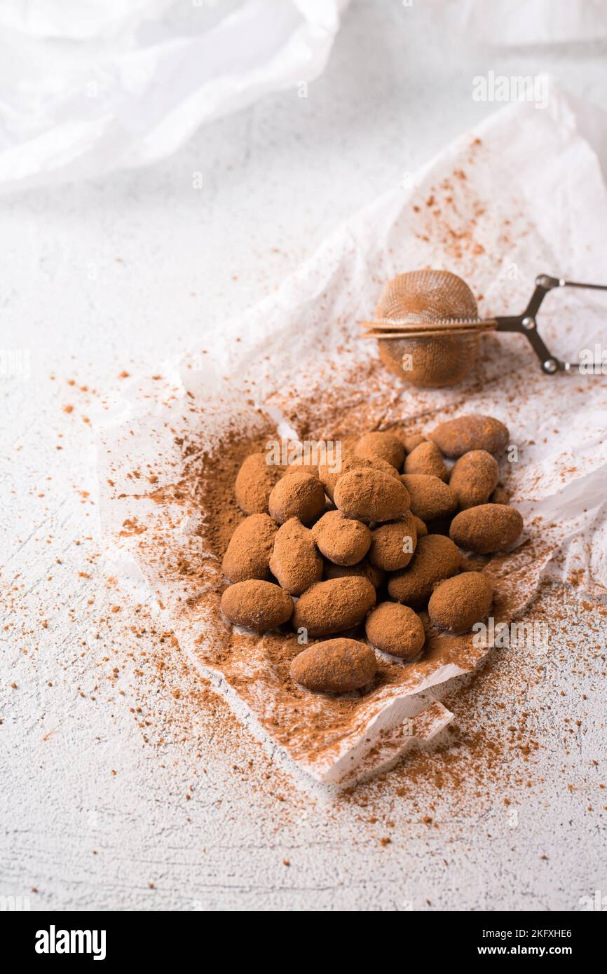 Roasted almonds in chocolate and cocoa powder on a white background ...