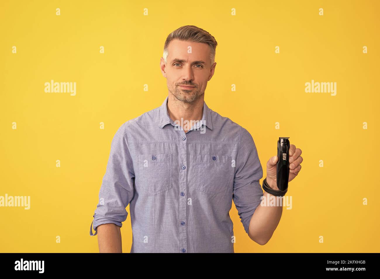 man hold electric razor on yellow background, shaving Stock Photo - Alamy
