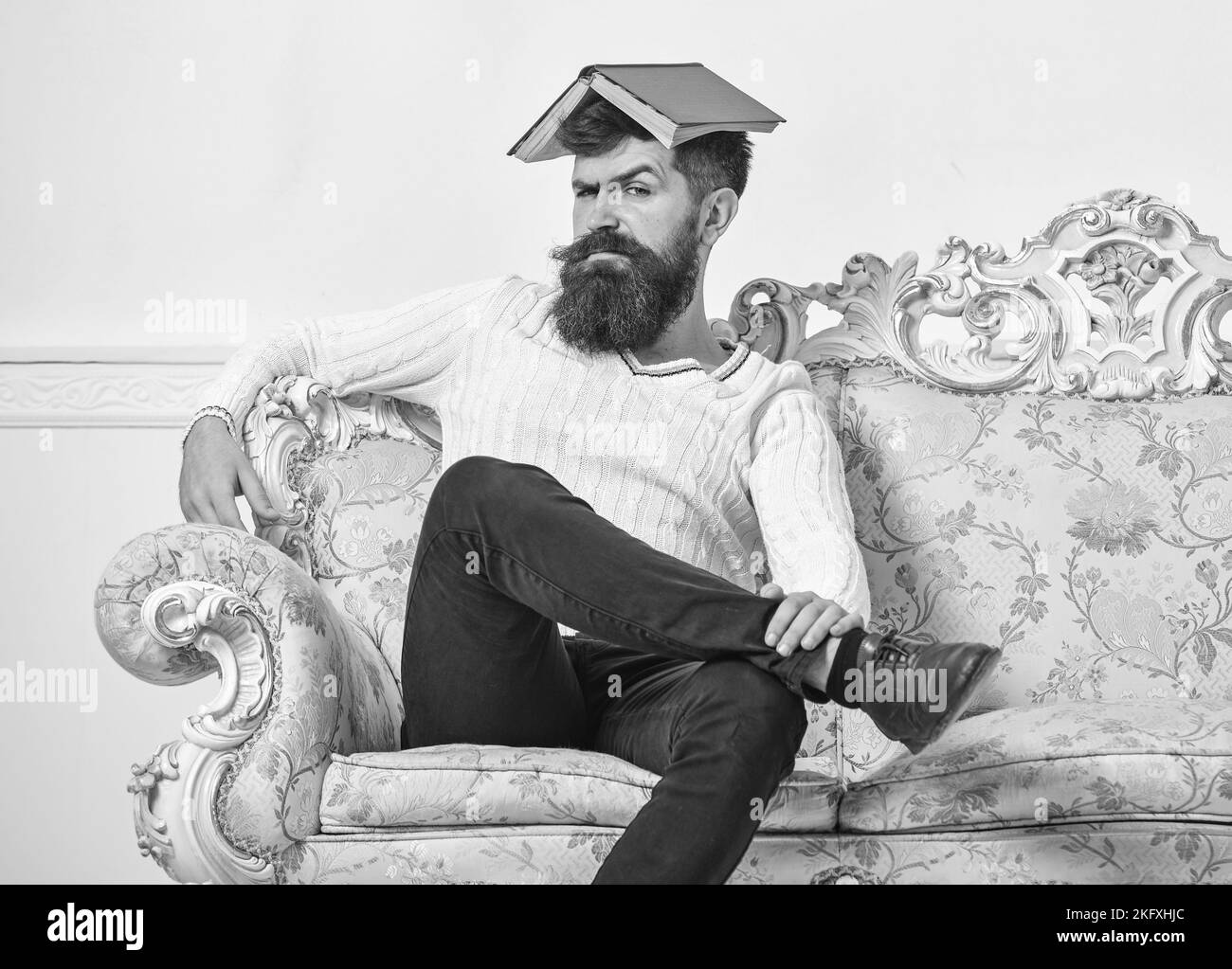 Macho sits with open book on head, like roof. Man with beard and ...