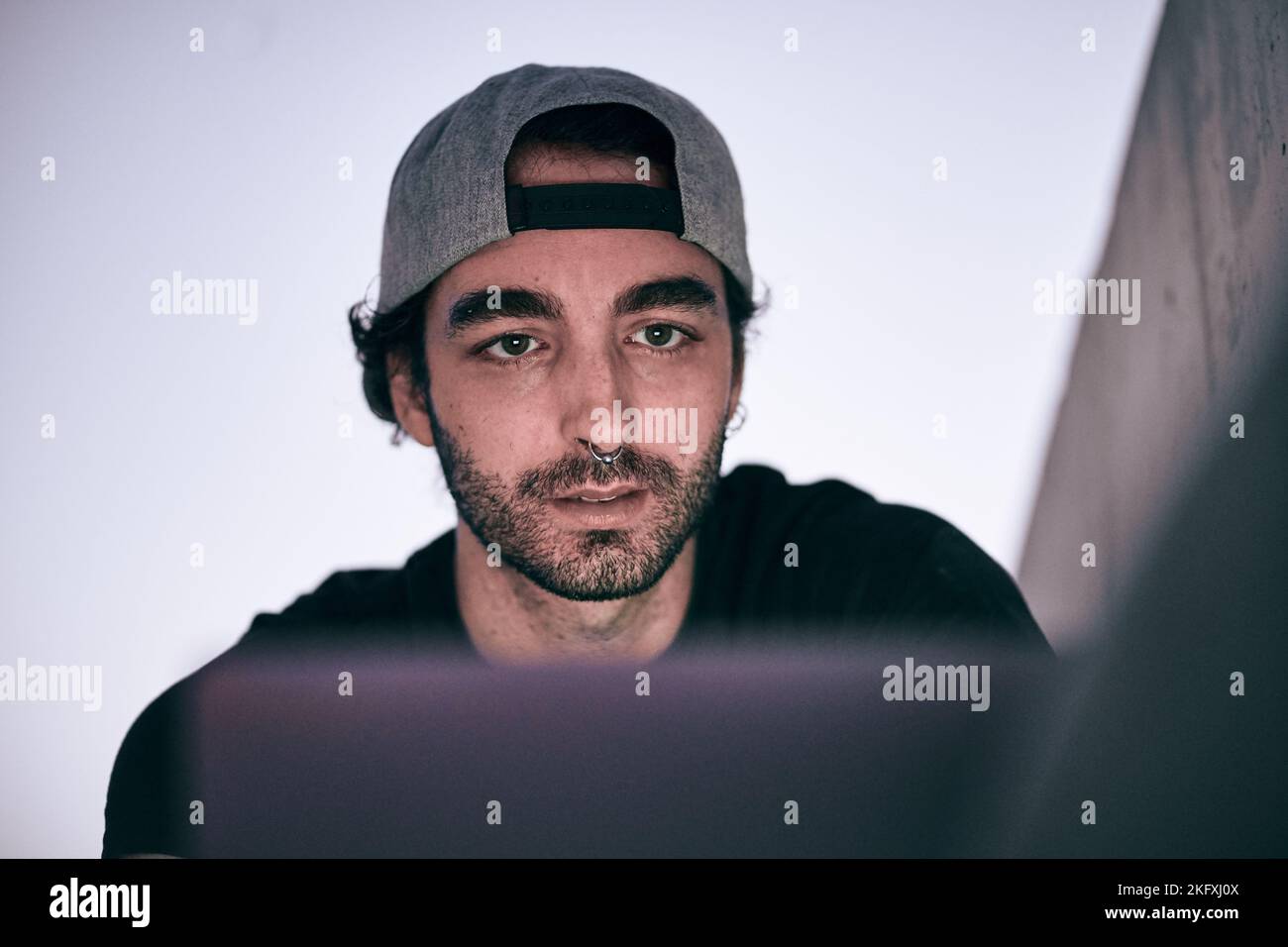 face of bearded caucasian guy with nose piercing gray cap black t-shirt ...