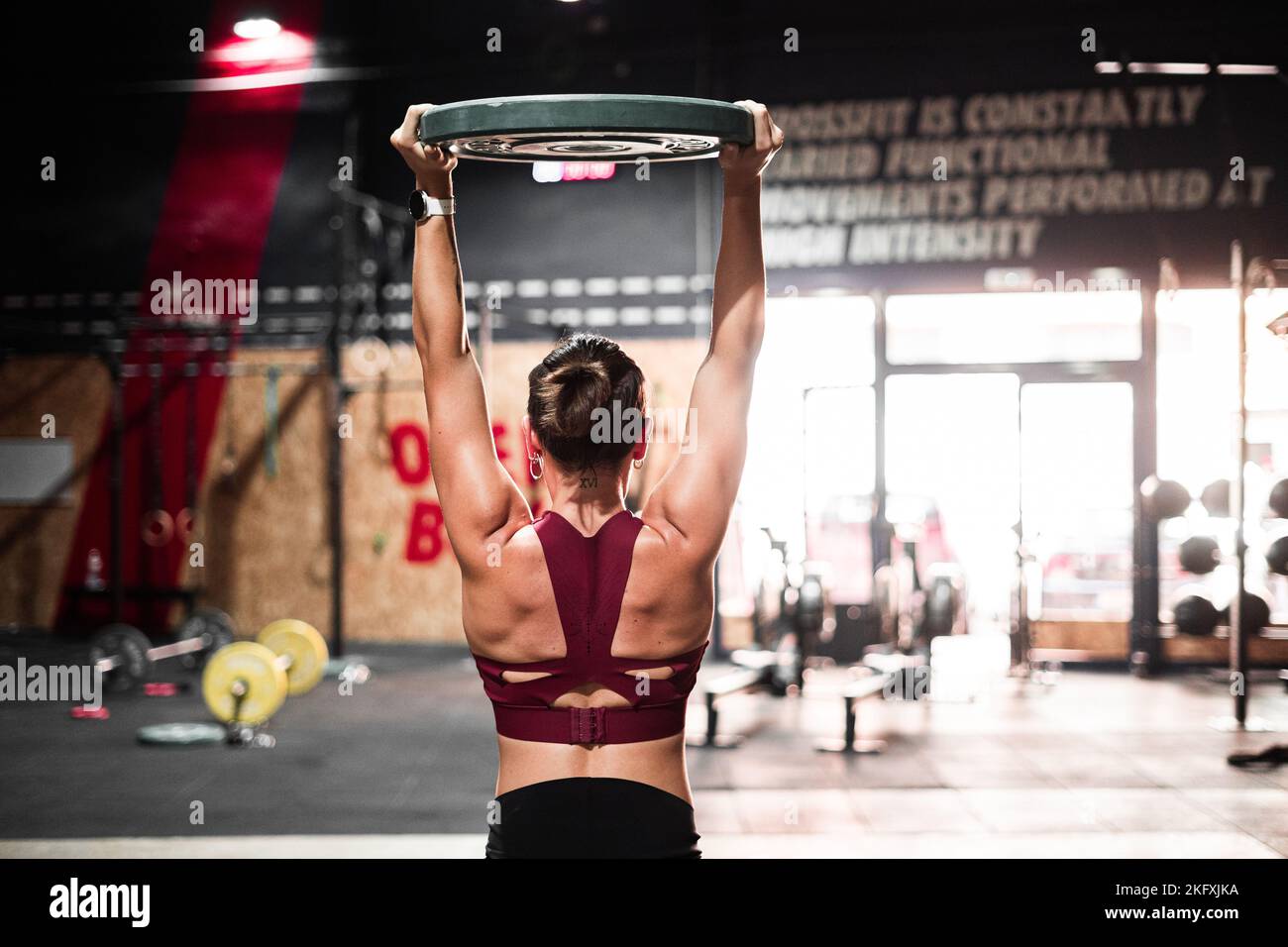 sporty caucasian girl on her back doing crossfit with a large round ...