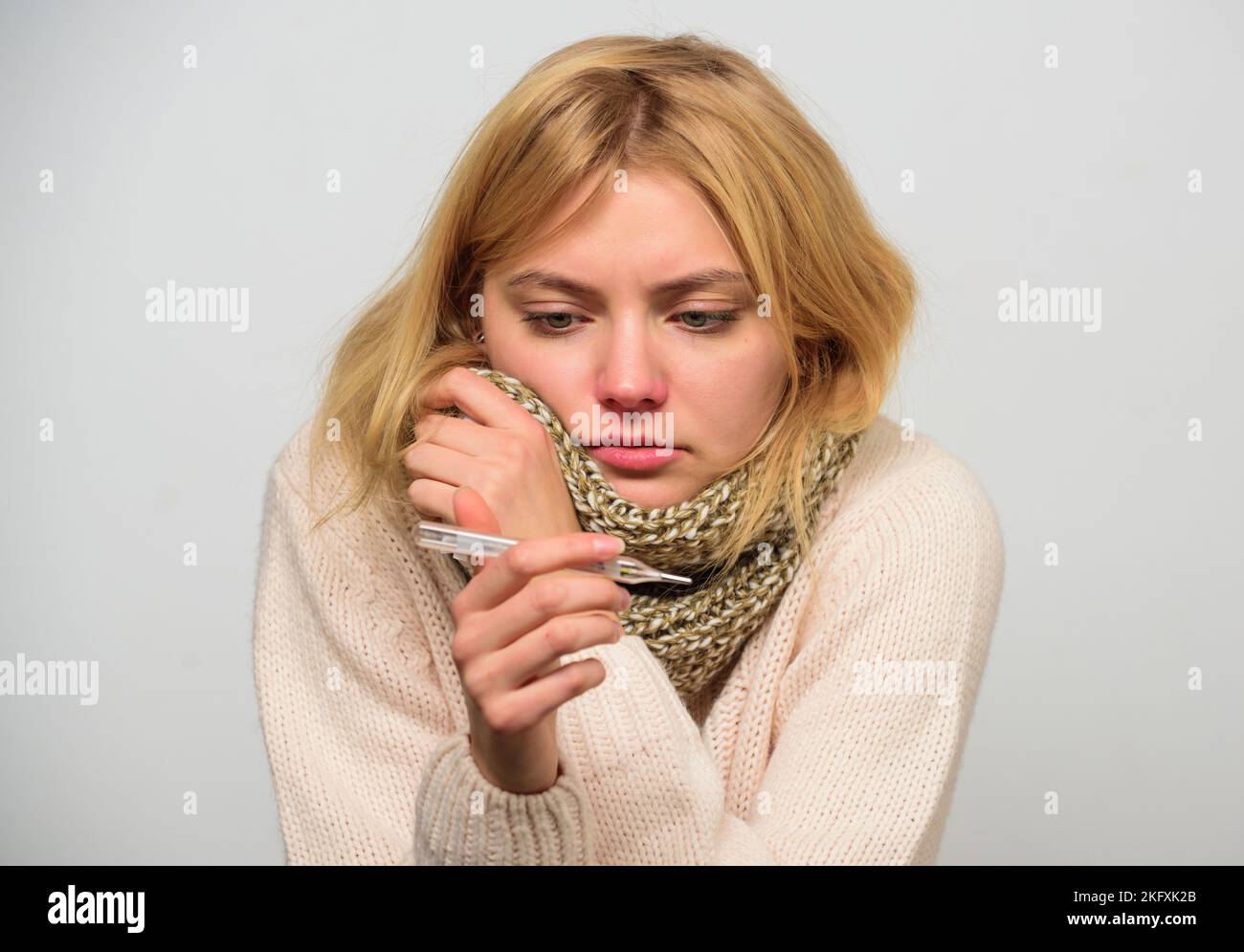 Woman feels badly ill sneezing. Girl in scarf hold thermometer and ...