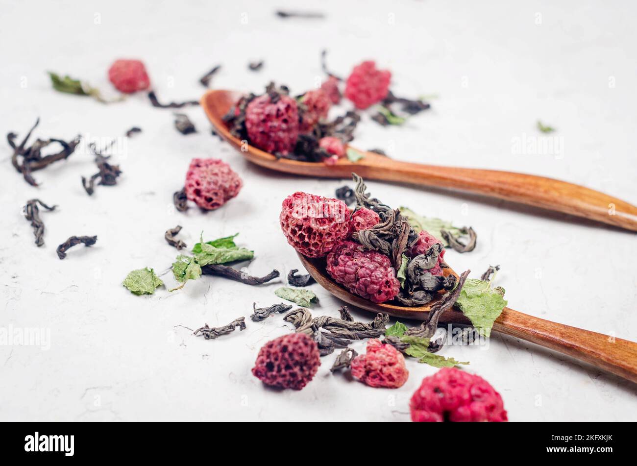 Dried fruit green tea with raspberries on vintage wooden tea spoons ...